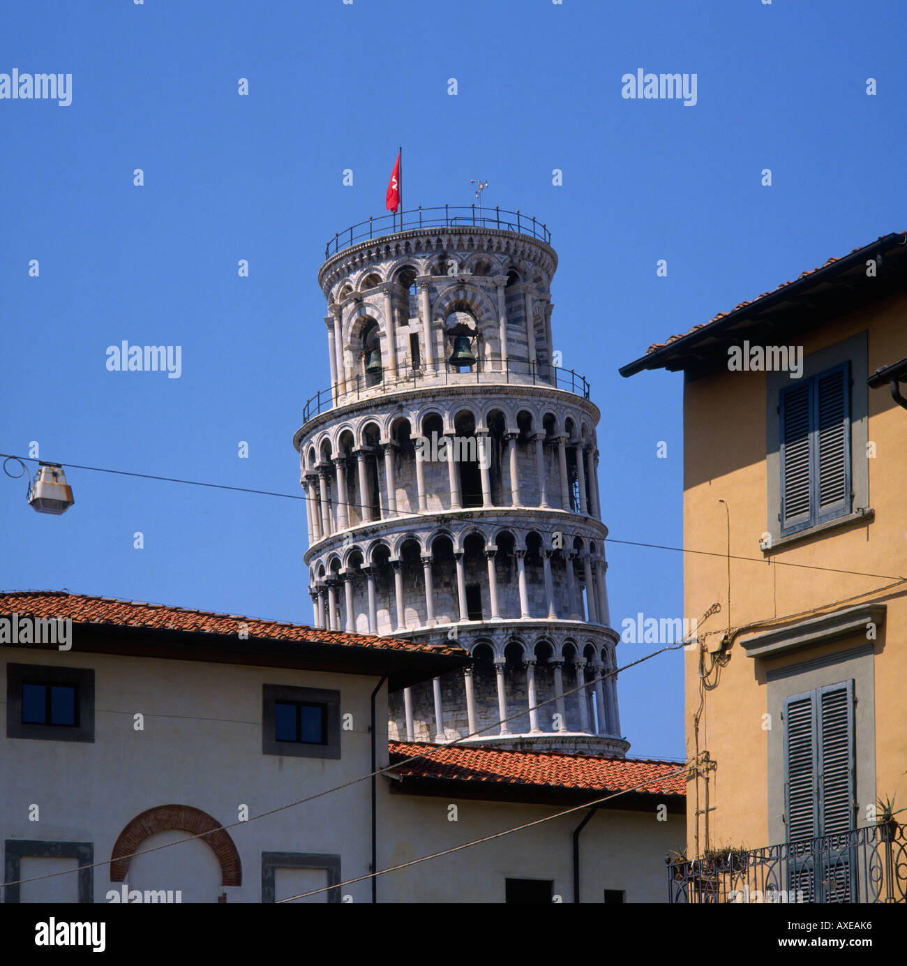 The top part of Leaning Tower of Pisa seen between local houses showing ...
