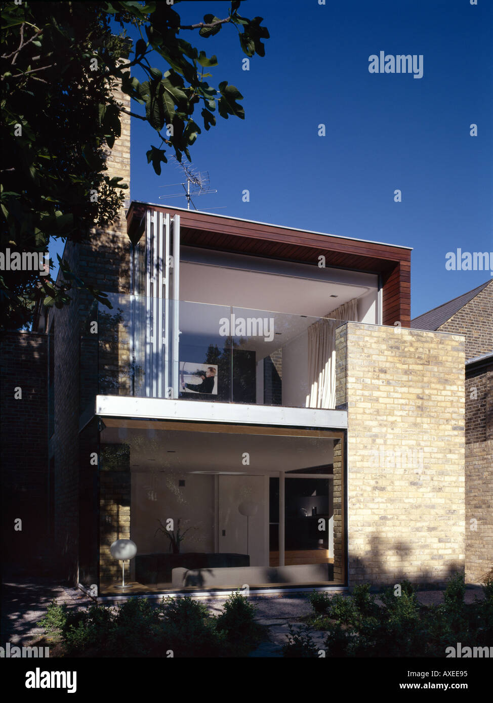 House Extension, Chiswick. Rear of house with sliding doors open ...