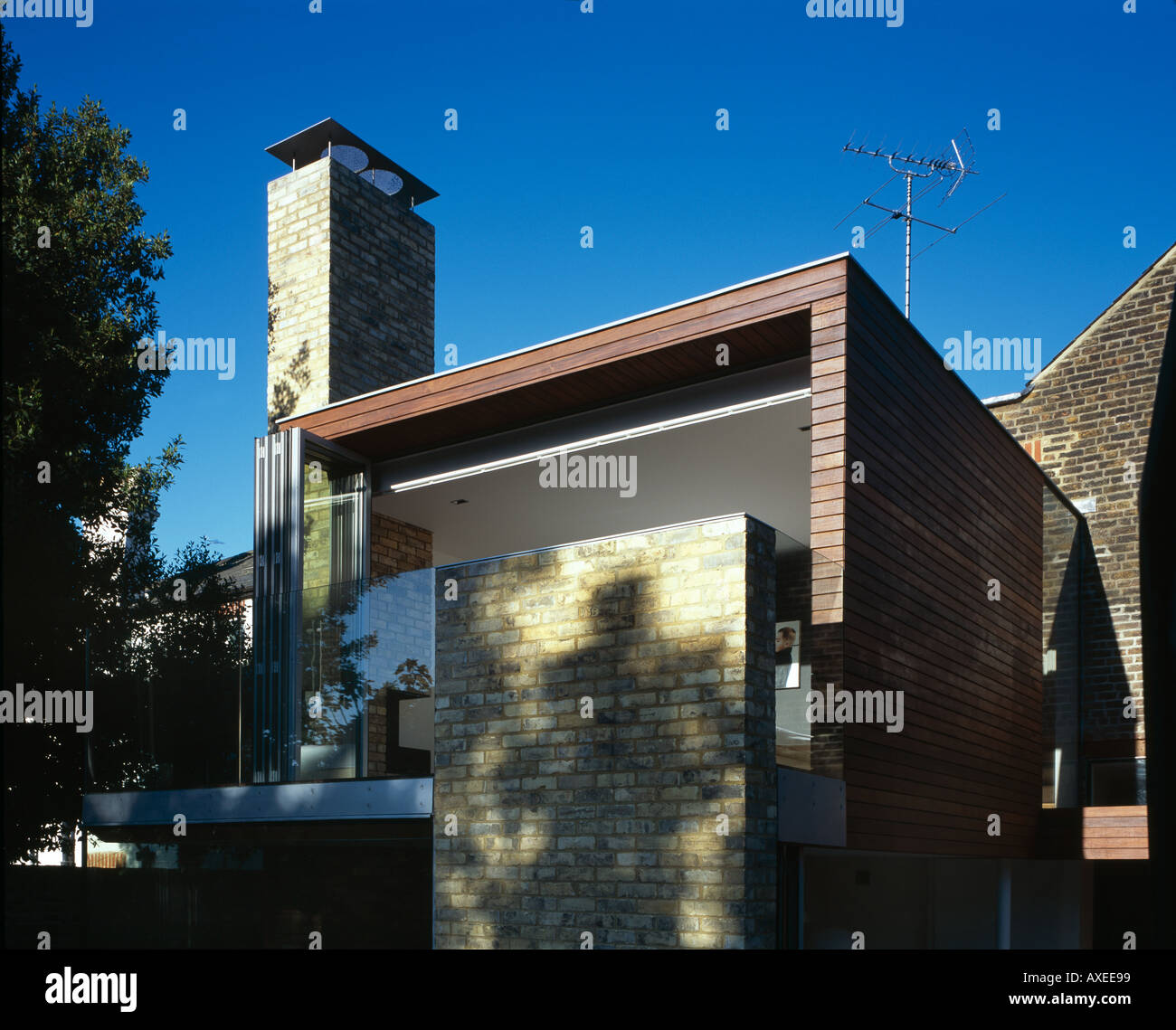 House Extension, Chiswick. Rear of house with sliding doors open ...