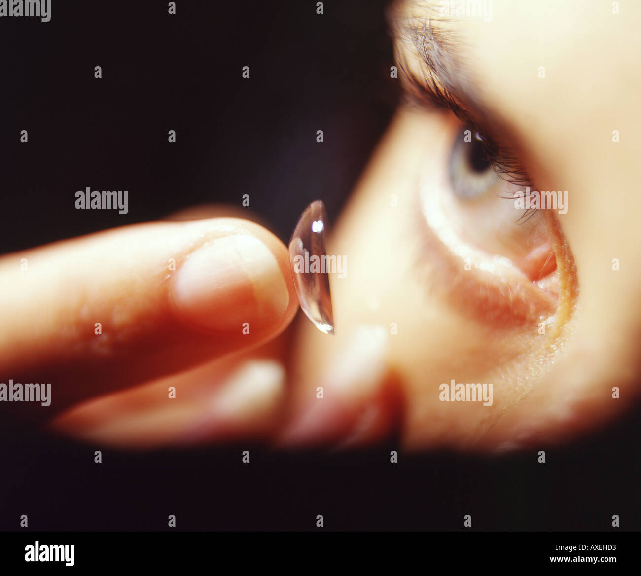 woman female girl young put insert eye contact contact lens finger eye ...