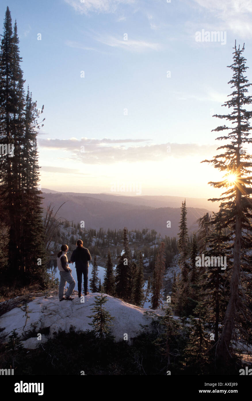 Hiking Couple Standing At A Mountain Overlook And Watching The Sun Rise ...
