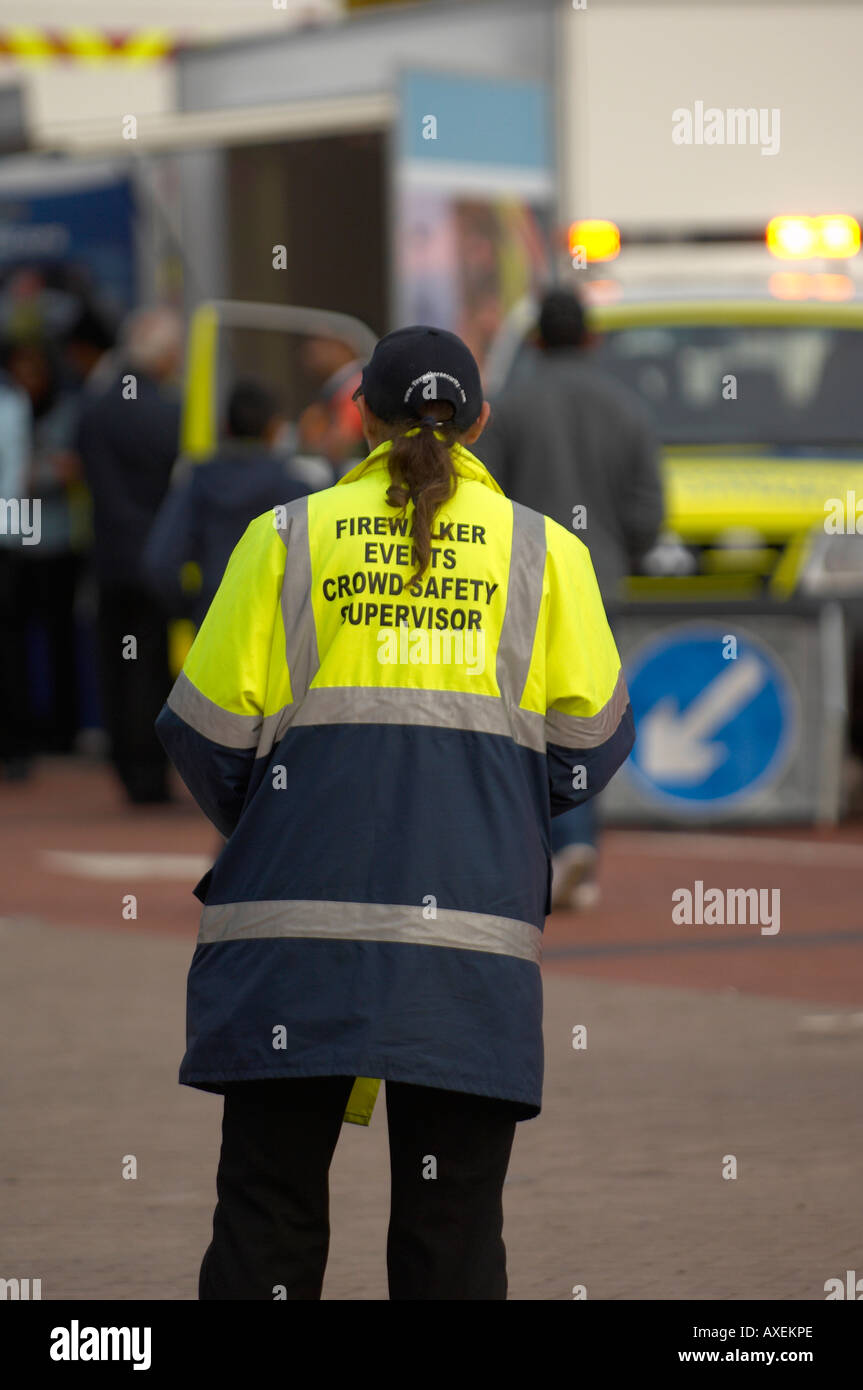Back view of woman wearing a High visibility jacket marked Crowd Safety ...