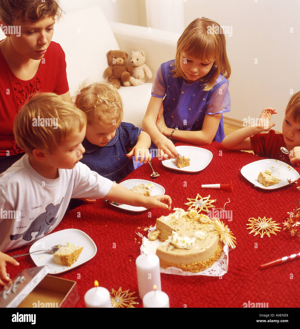 Woman watching at four children eating party cake Stock Photo - Alamy