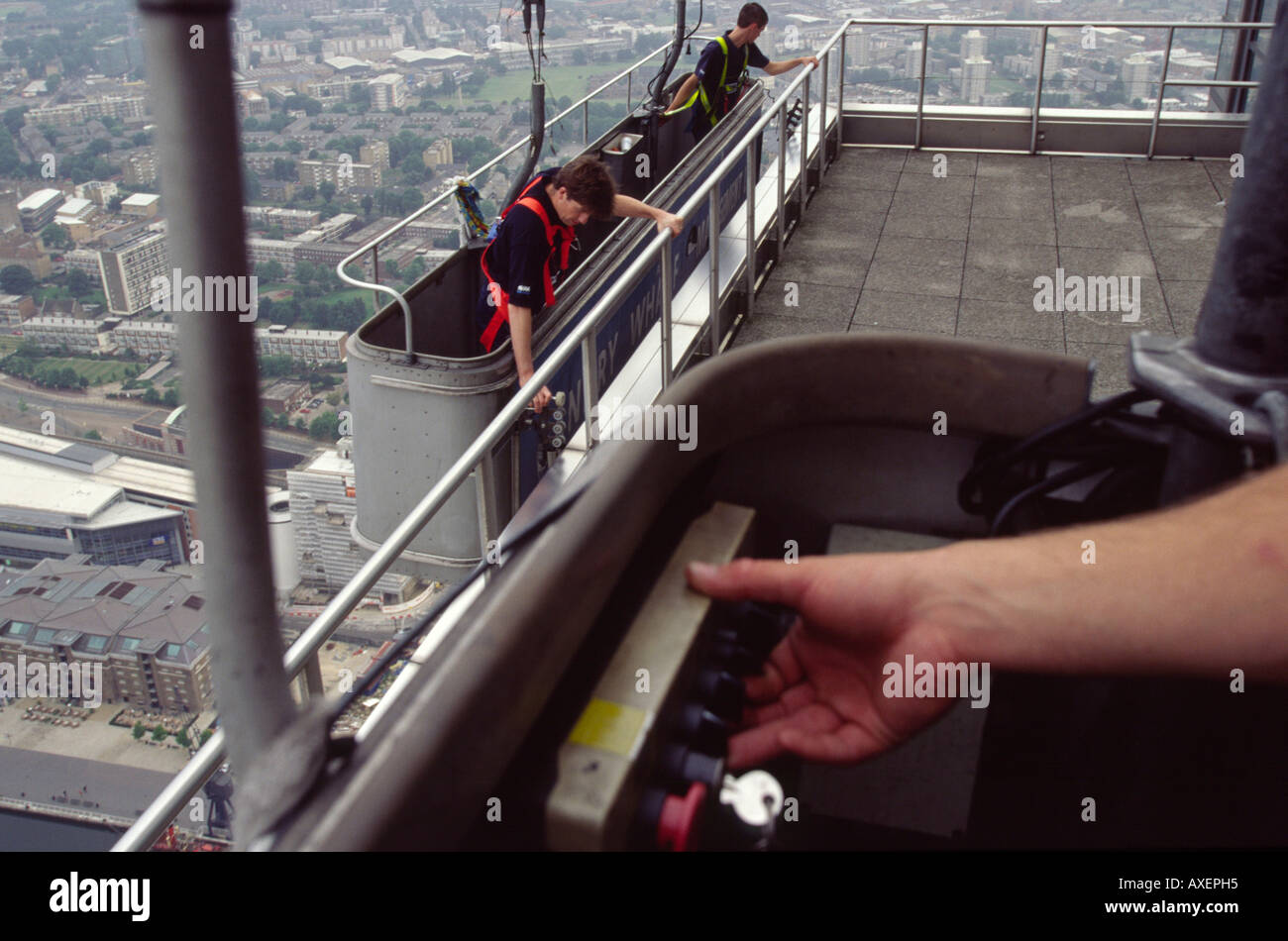 Window cleaners in a cleaning cradle at Canary Wharf Tower in London ...