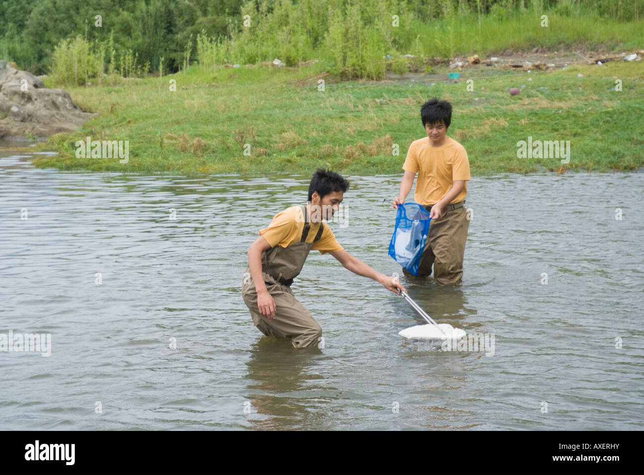 Two people cleaning river Stock Photo - Alamy