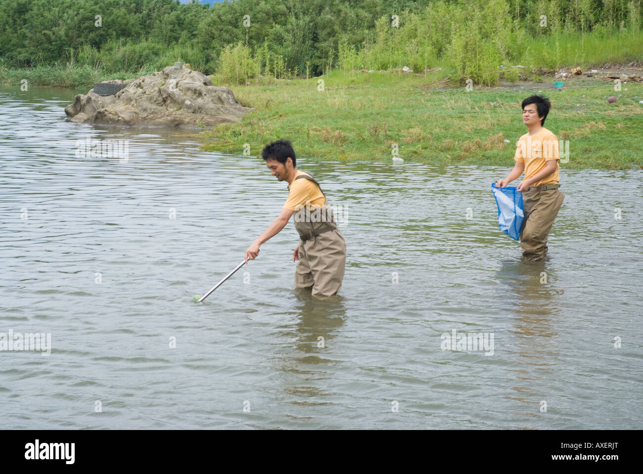 Two people cleaning river Stock Photo - Alamy