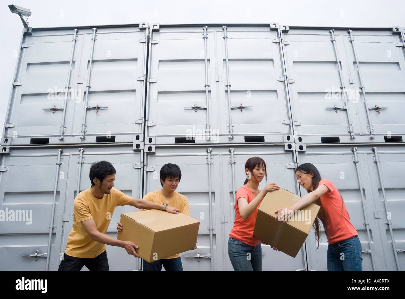 Young people carrying boxes Stock Photo - Alamy
