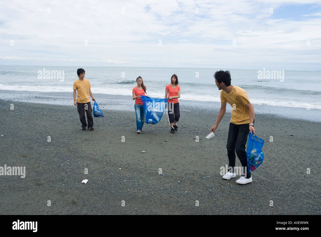 Young people cleaning beach Stock Photo - Alamy