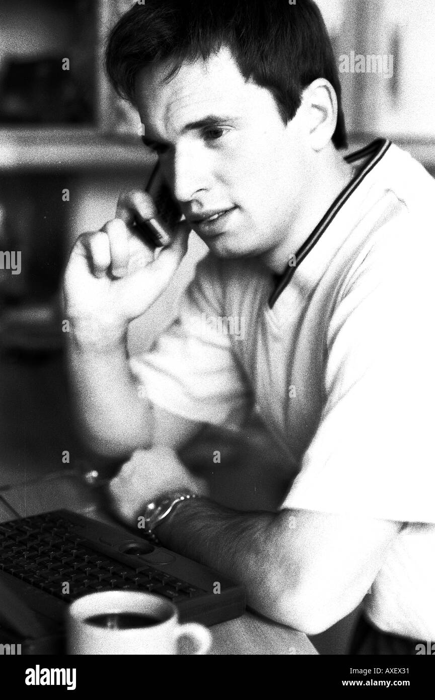 man male age 30 35 adult dark haired talk work sit lean table telephone ...