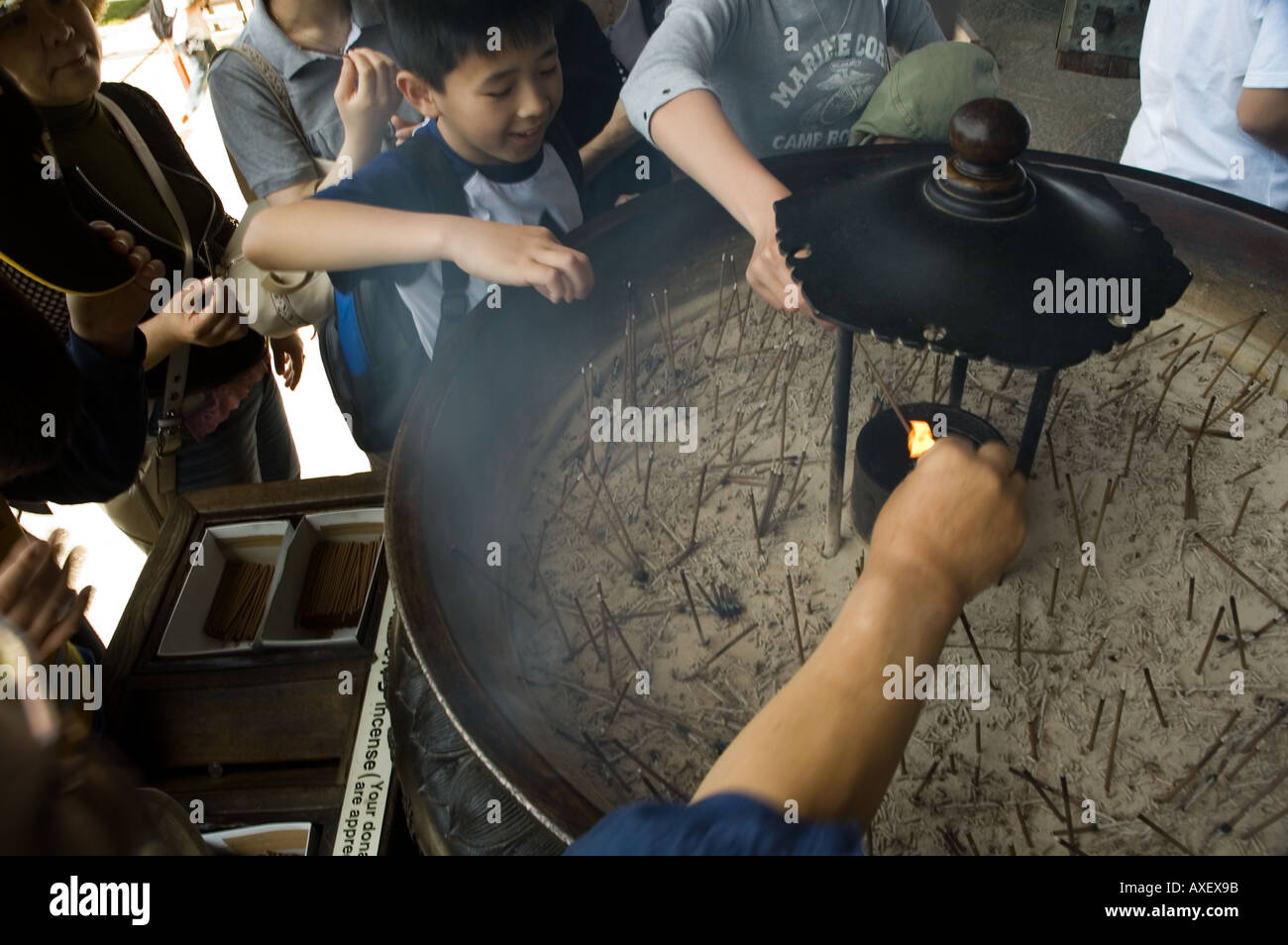 Worshipers place incense sticks in a cauldron outside of Todaiji temple ...