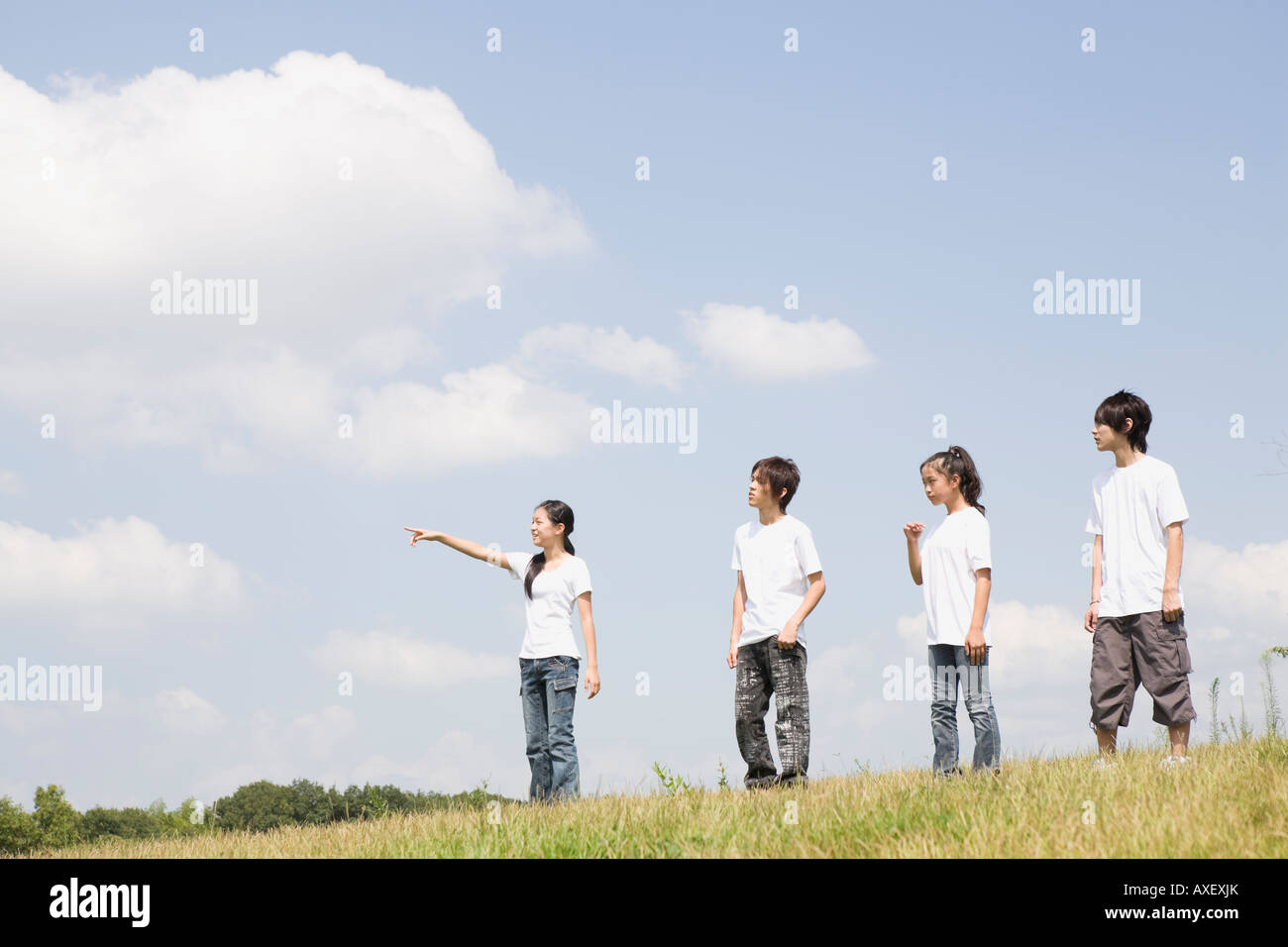 Teenagers standing in grass field Stock Photo - Alamy