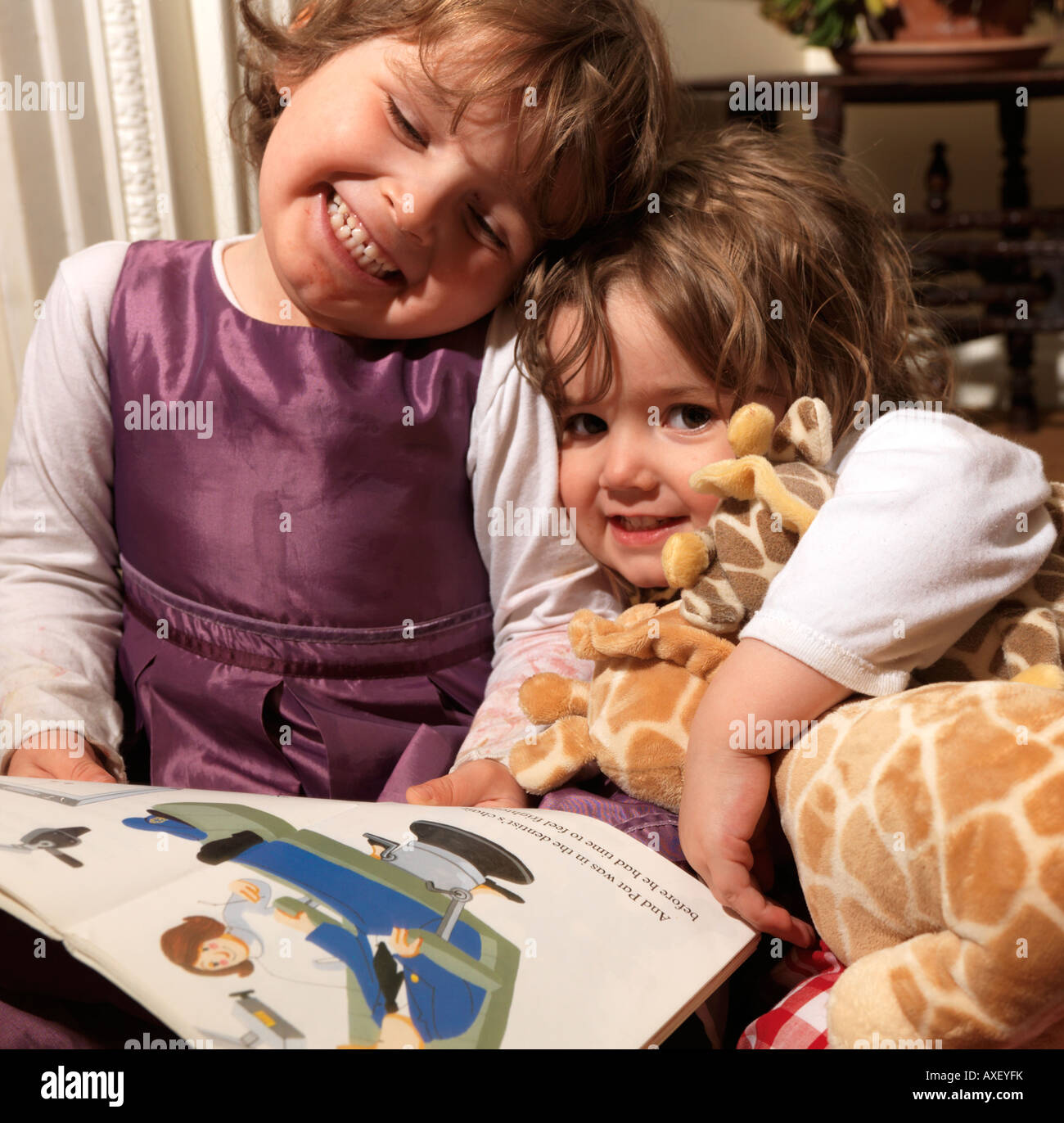 Sisters Reading a Book Stock Photo - Alamy