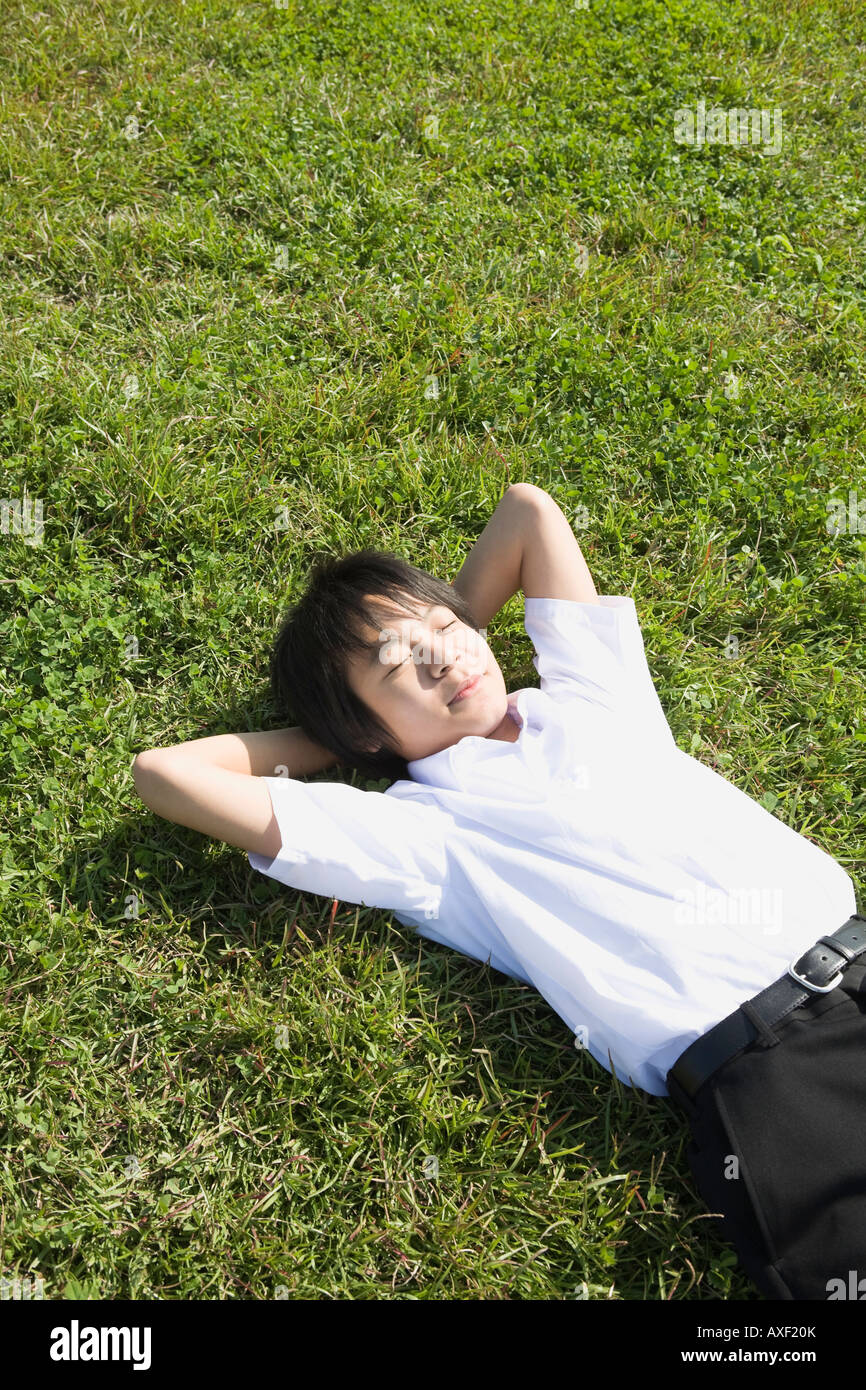 Schoolboy sleeping in grass field Stock Photo - Alamy