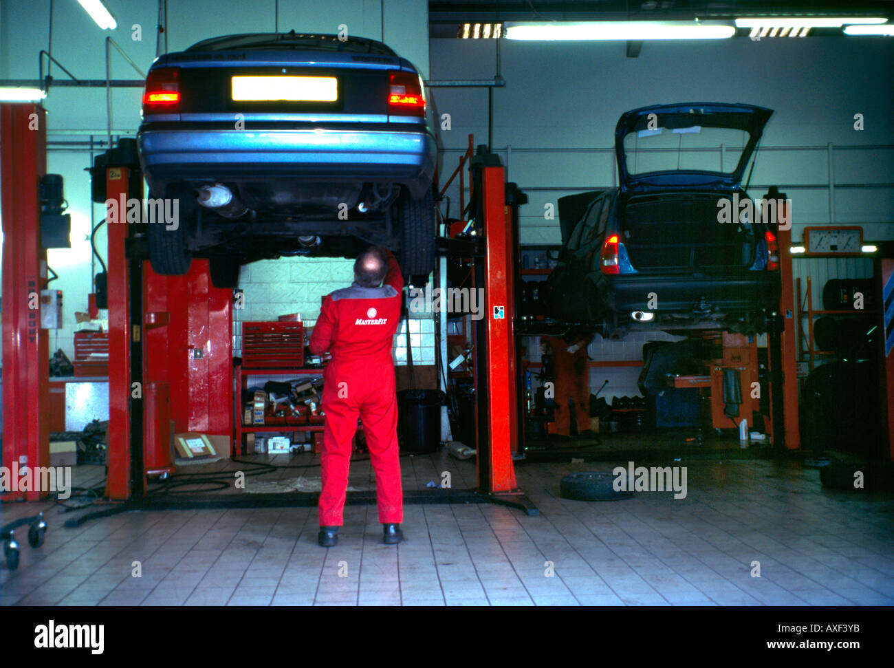 Mechanics Working On Car On Ramps Stock Photo, Royalty Free Image ...