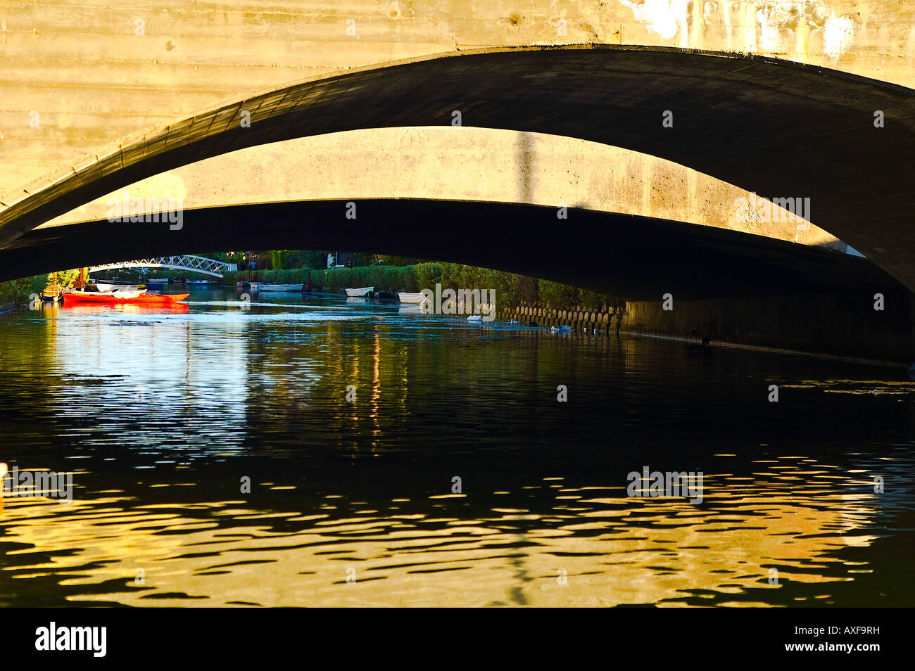 Looking under two concrete arch bridges as the sun reflects in the ...