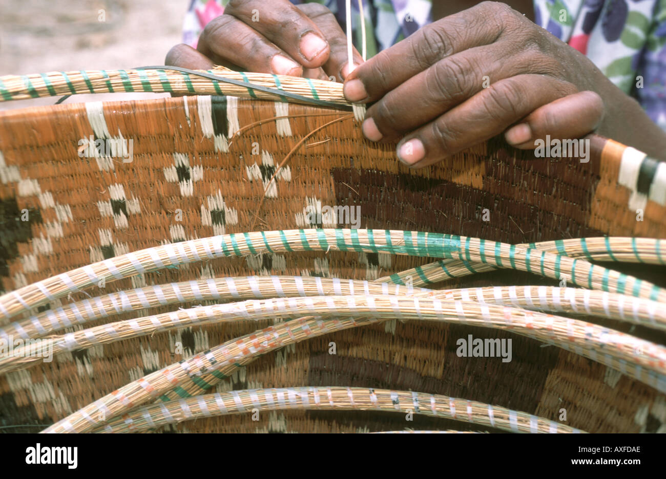 Close up of a ladies hands weaving a tradional basket Gumare Botswana ...