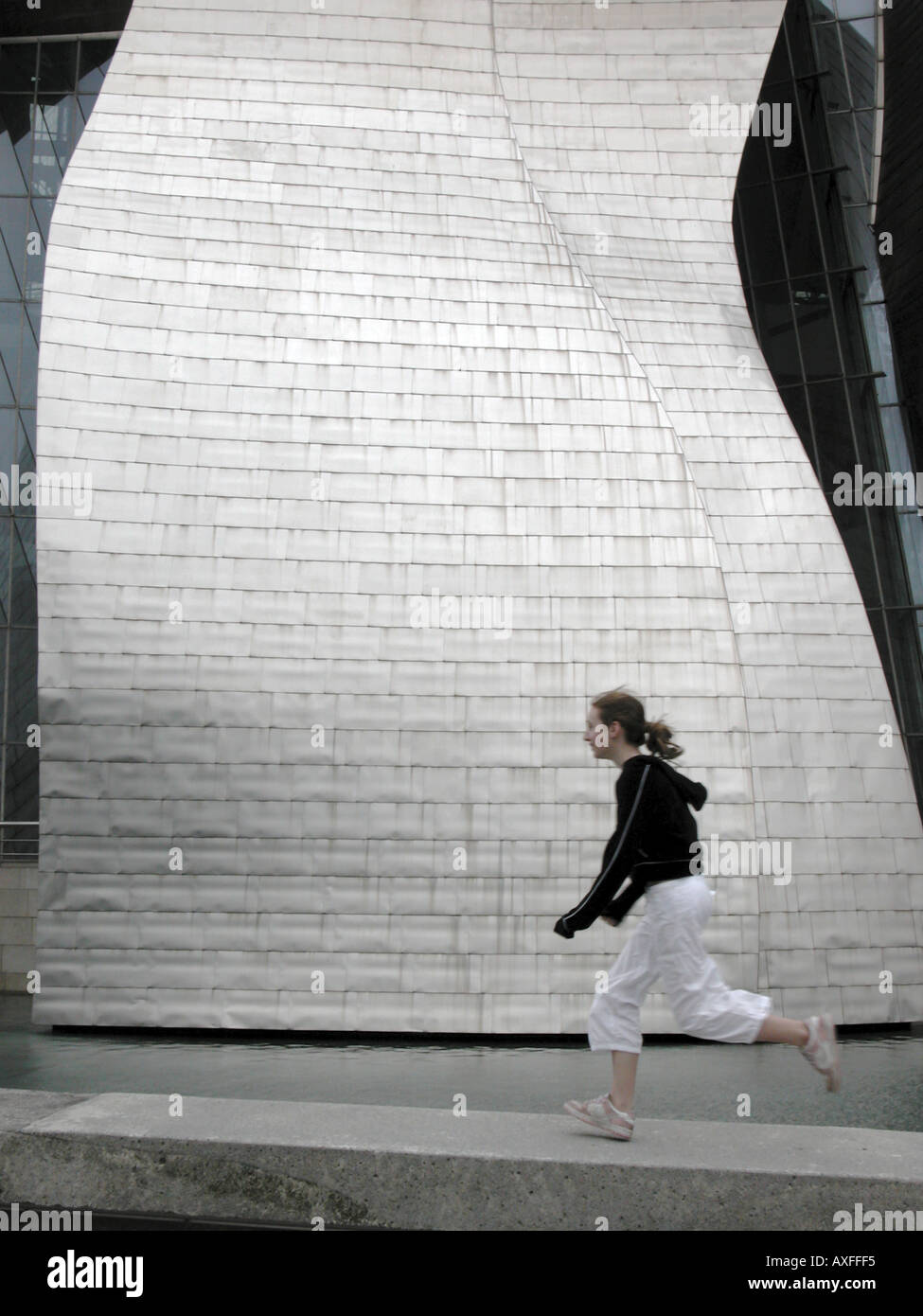girl running on wall in front of Guggenheim Museum Bilbao Stock Photo ...