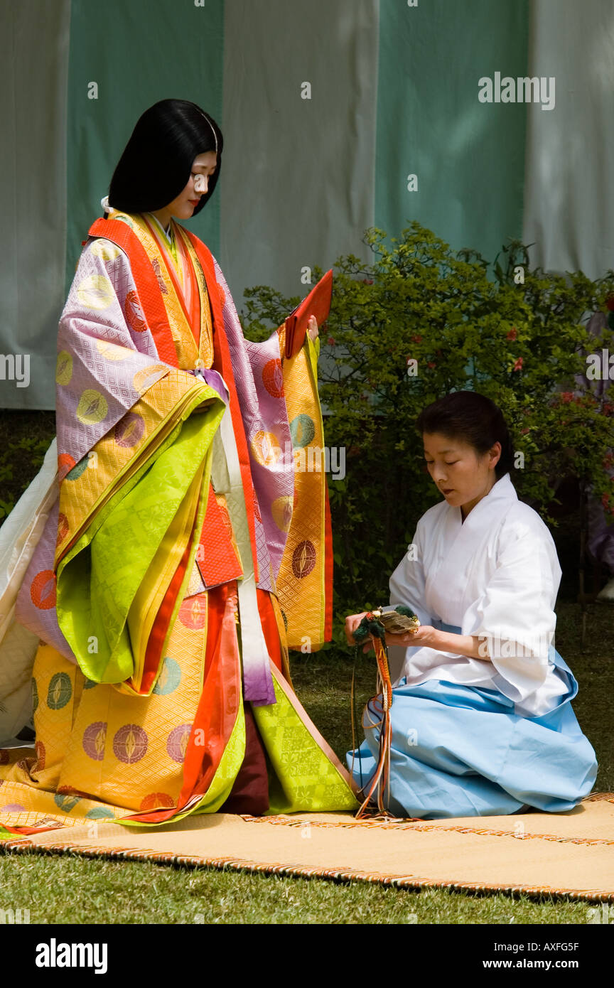 A servant helps a woman dressed in Heian period costume at the Gokusui ...