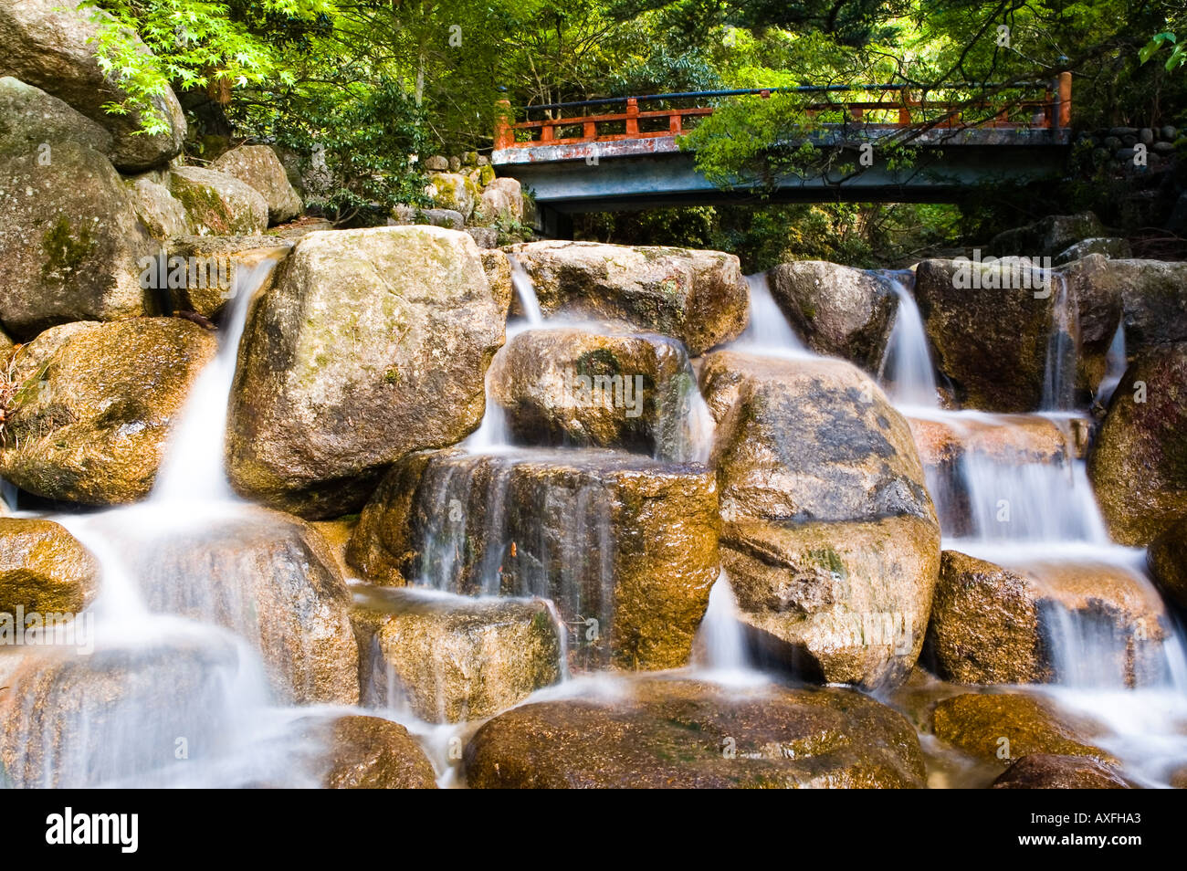 A bridge stretches over a waterfall near the base of Mount Misen on ...