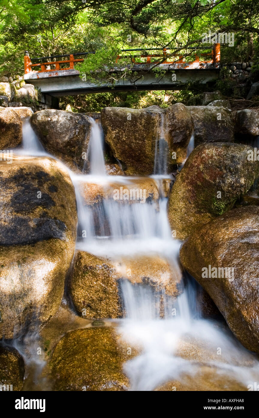 A bridge stretches over a waterfall near the base of Mount Misen on ...