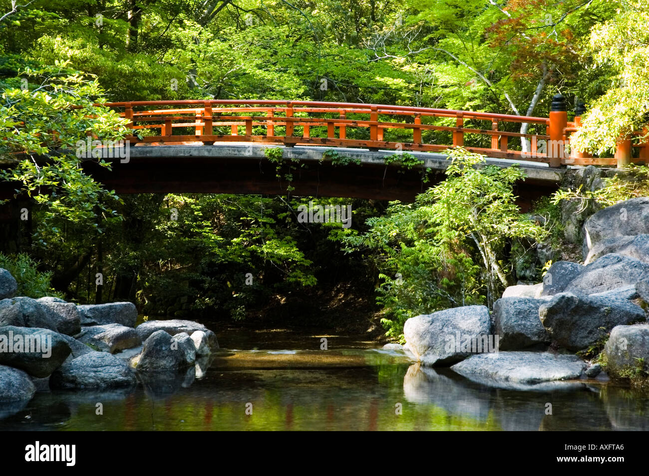 A bridge stretches over a river near the base of Mount Misen on ...