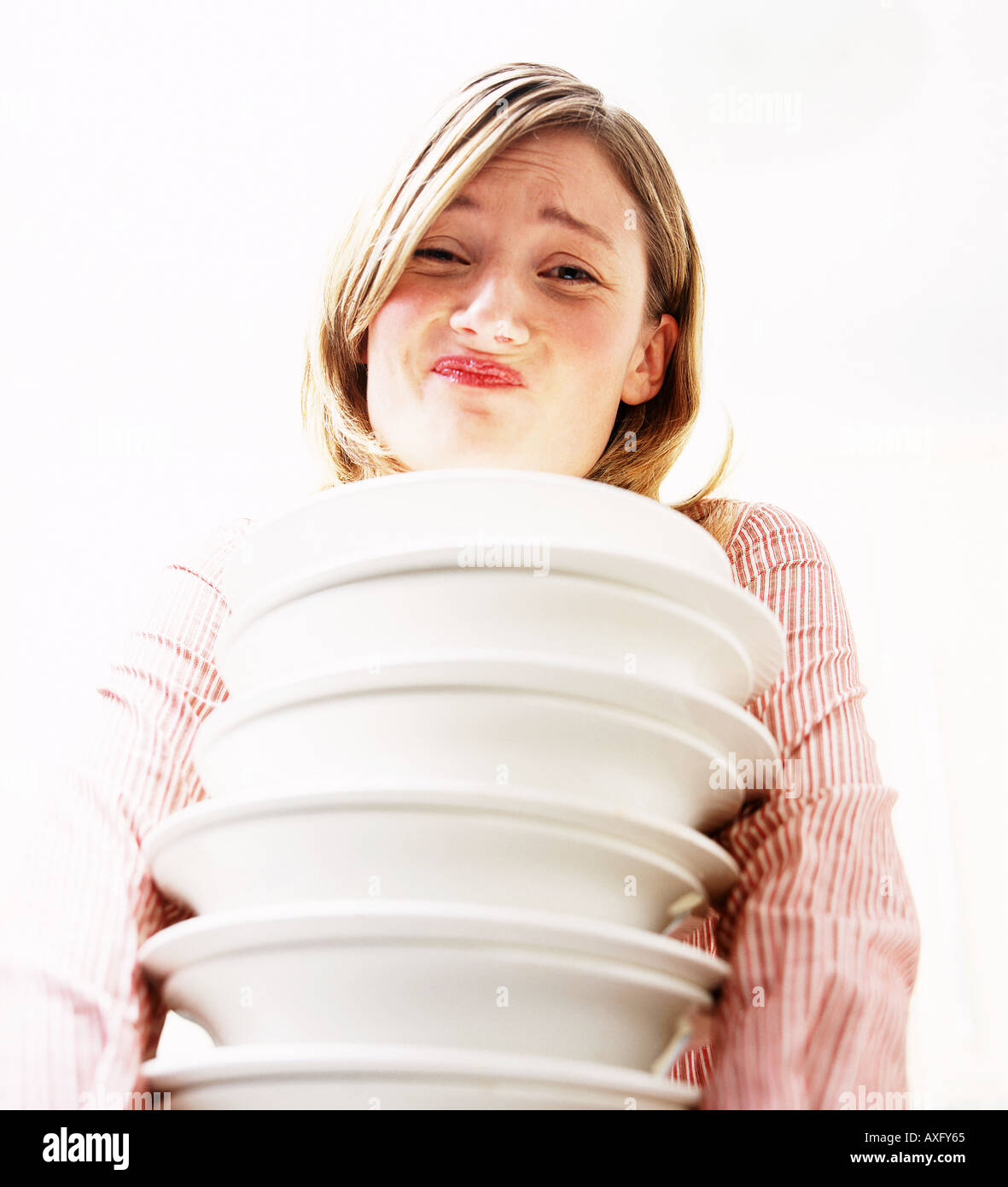 Woman in kitchen carries a stack of plates Stock Photo - Alamy