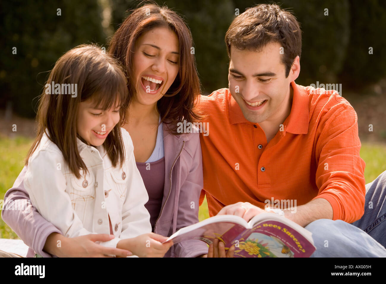 Hispanic family reading outdoors Stock Photo - Alamy