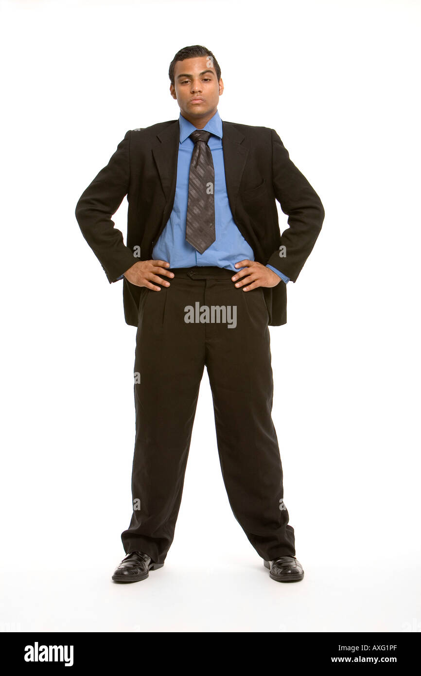 Young business man in a suit and tie standing with feet apart and arms ...