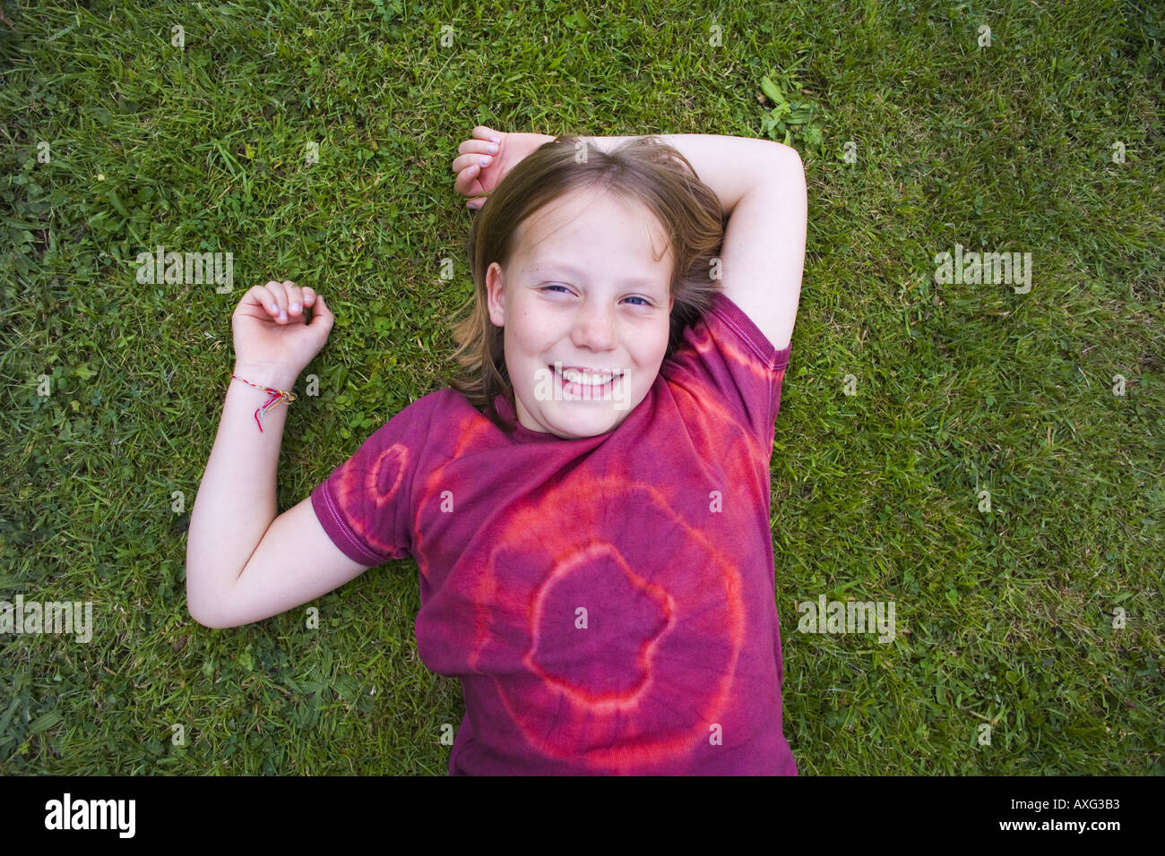 UK CORNWALL 8 9 10 YEAR OLD GIRL LYING ON GRASS LAWN PARK GARDEN FIELD ...