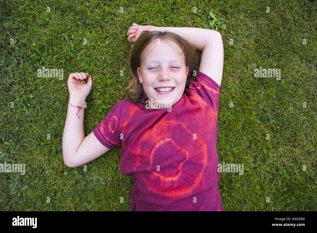 UK CORNWALL 8 9 10 YEAR OLD GIRL LYING ON GRASS LAWN PARK GARDEN FIELD ...