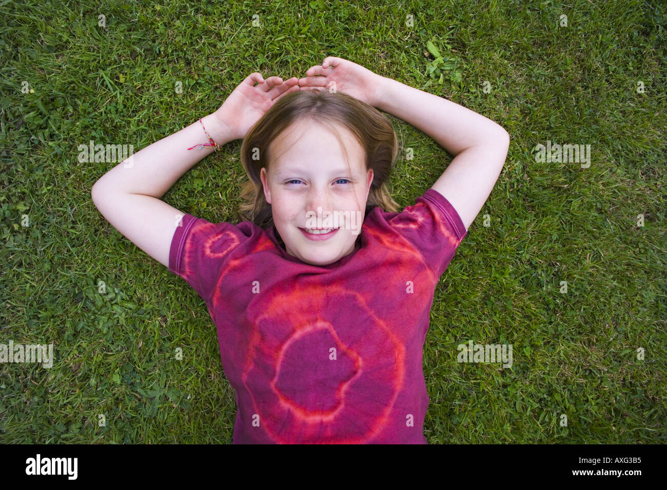 UK CORNWALL 8 9 10 YEAR OLD GIRL LYING ON GRASS LAWN PARK GARDEN FIELD ...