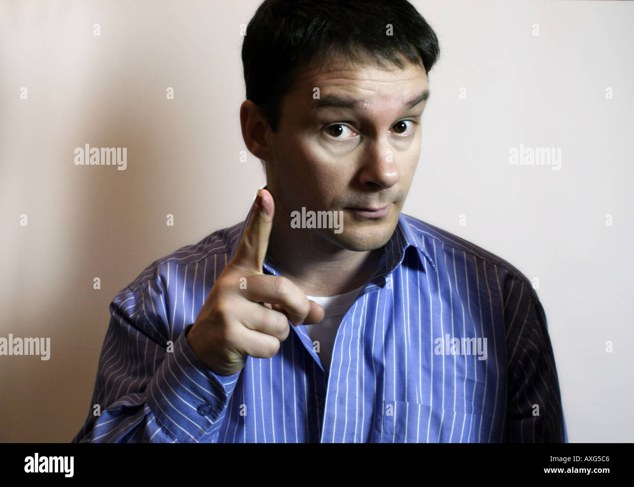 Tentative look from man warning with his finger Stock Photo - Alamy