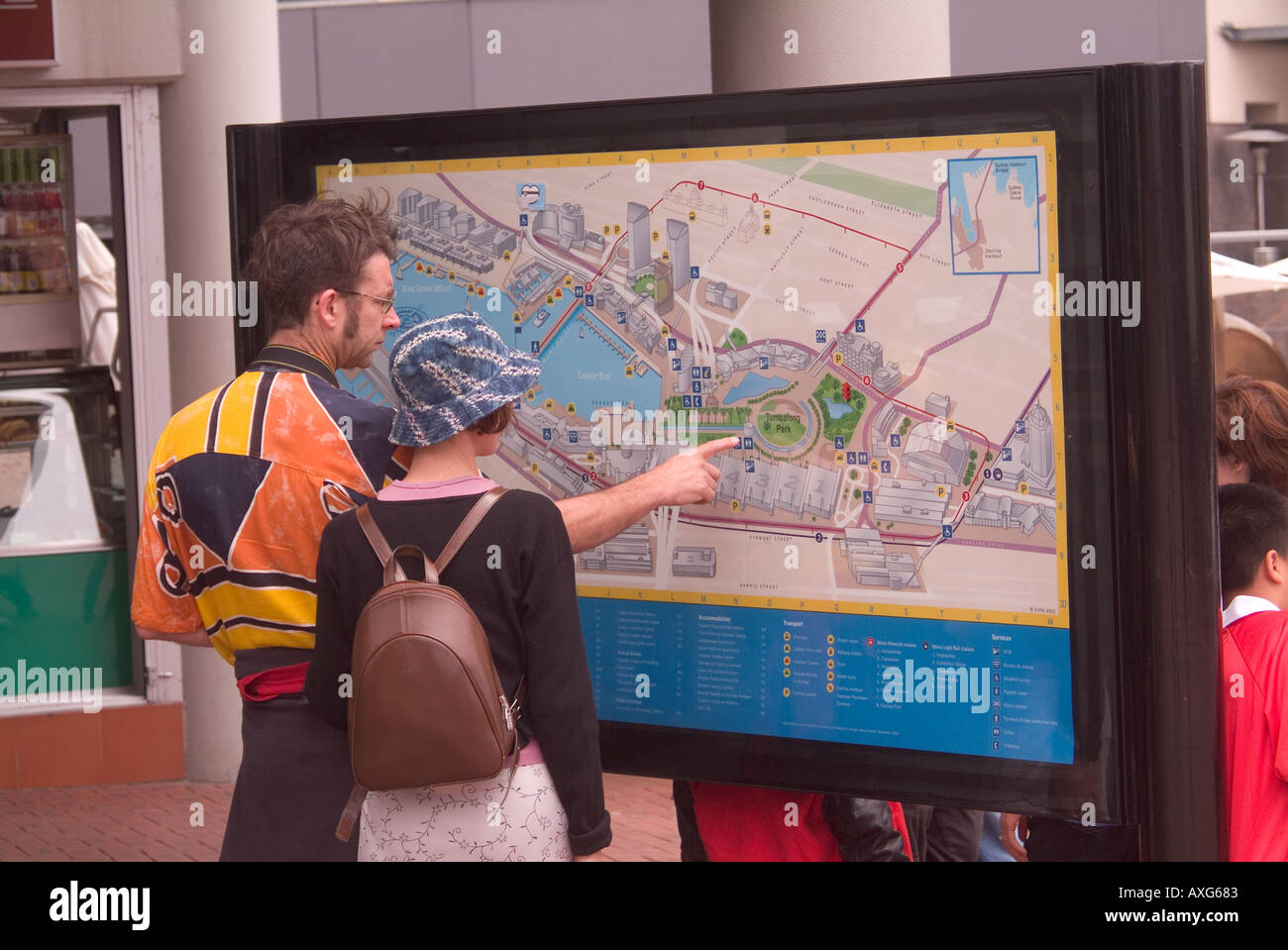 Two tourists using a city directory map in Sydney, Australia to find ...