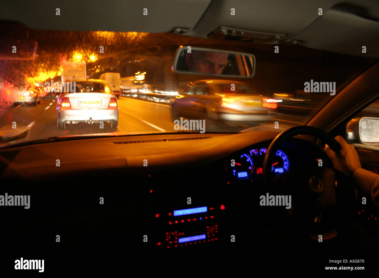 View through car windscreen whilst driving along motorway at night ...