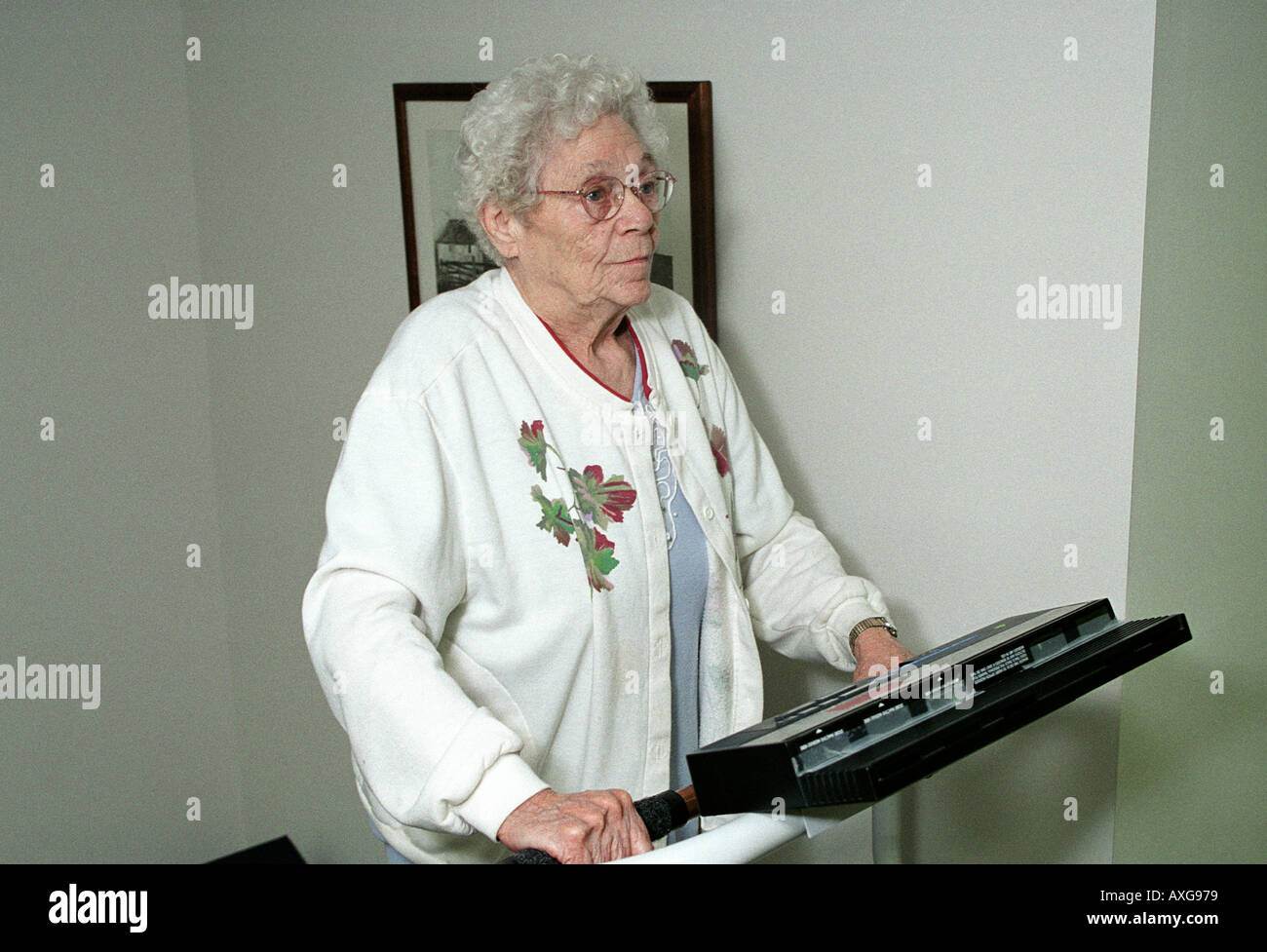 82 year old senior female checks her weight on scale and exercises to ...