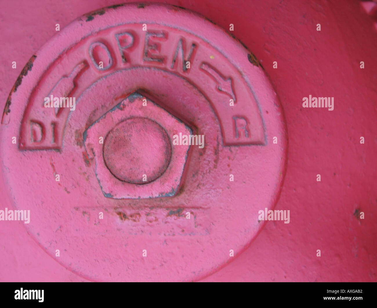 Red top of a hydrant showing which way to open Stock Photo - Alamy