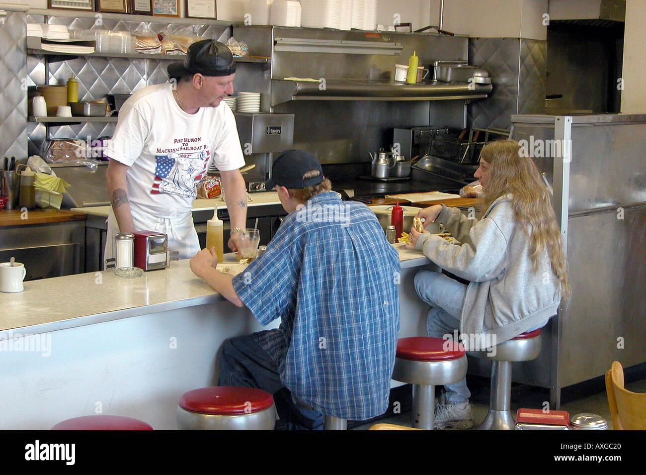 Short order cook talks with patron customer in a small restaurant Stock ...