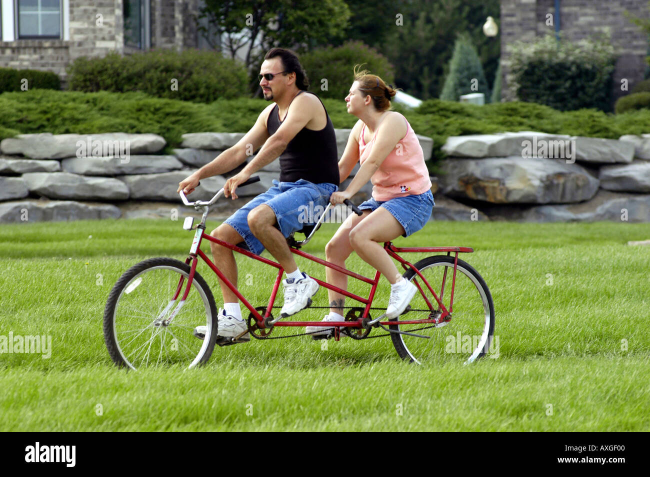 Couple ride a tandem bicycle built for two Stock Photo - Alamy