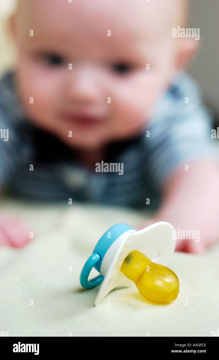 Baby reaching for pacifier Stock Photo - Alamy