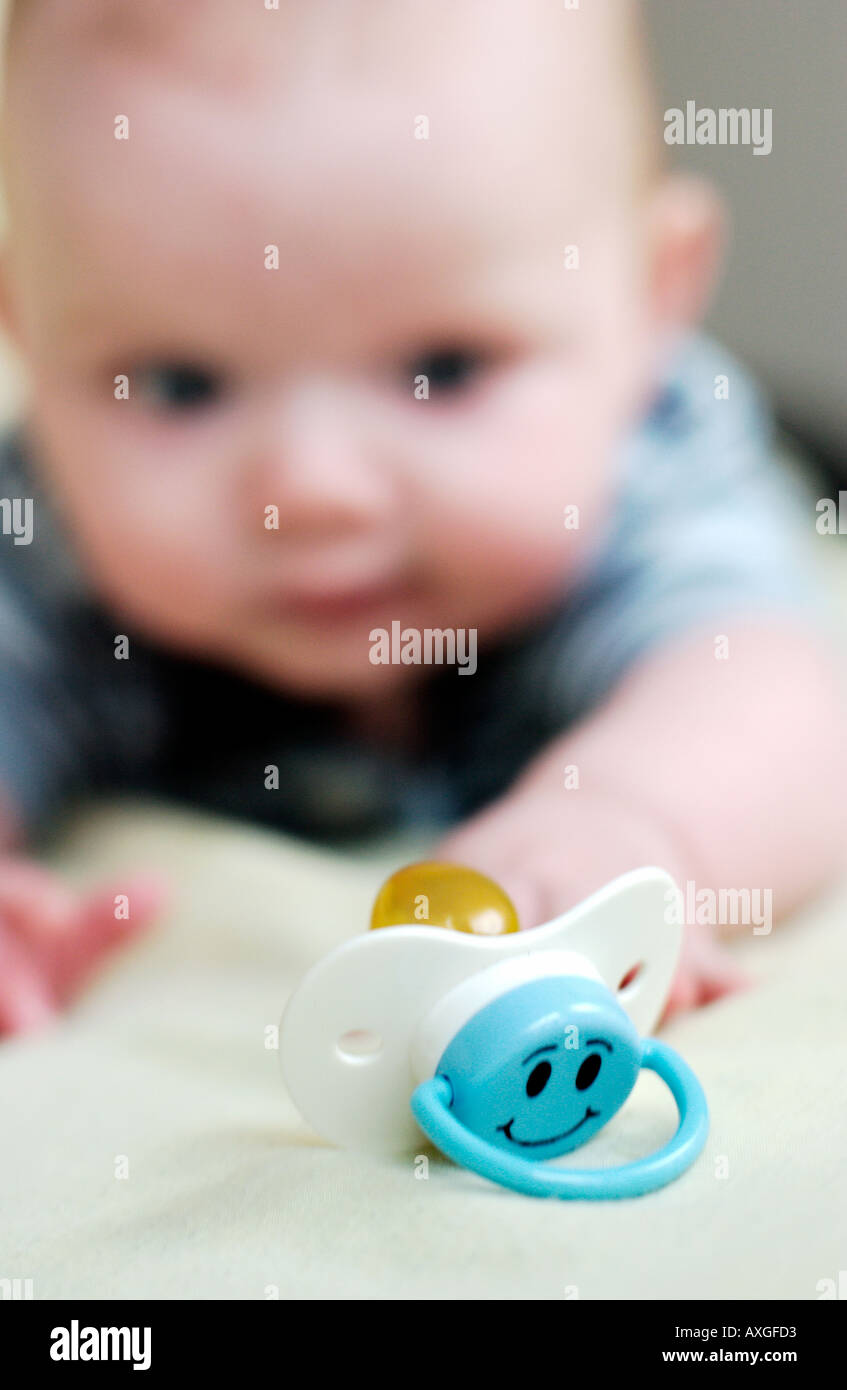 Baby reaching for pacifier Stock Photo - Alamy