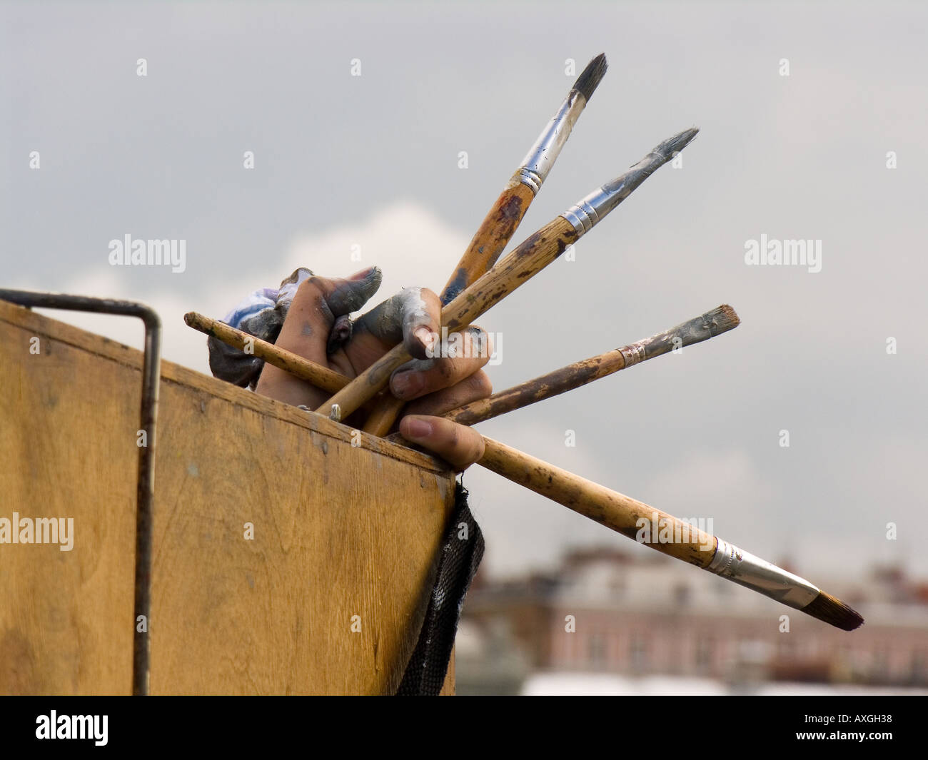Painting brushes in hand of artist Stock Photo - Alamy