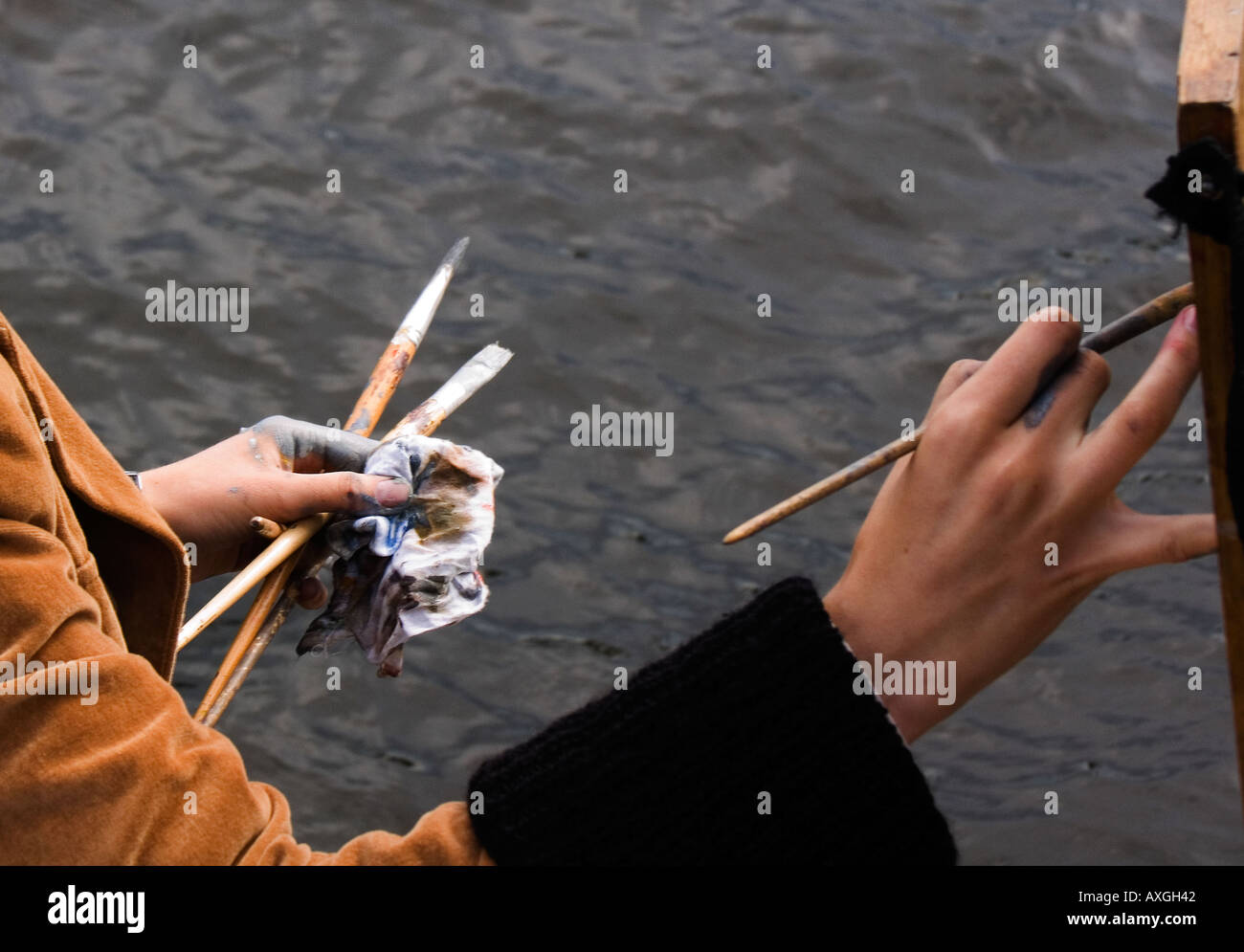 Painting brushes in hand of artist Stock Photo - Alamy