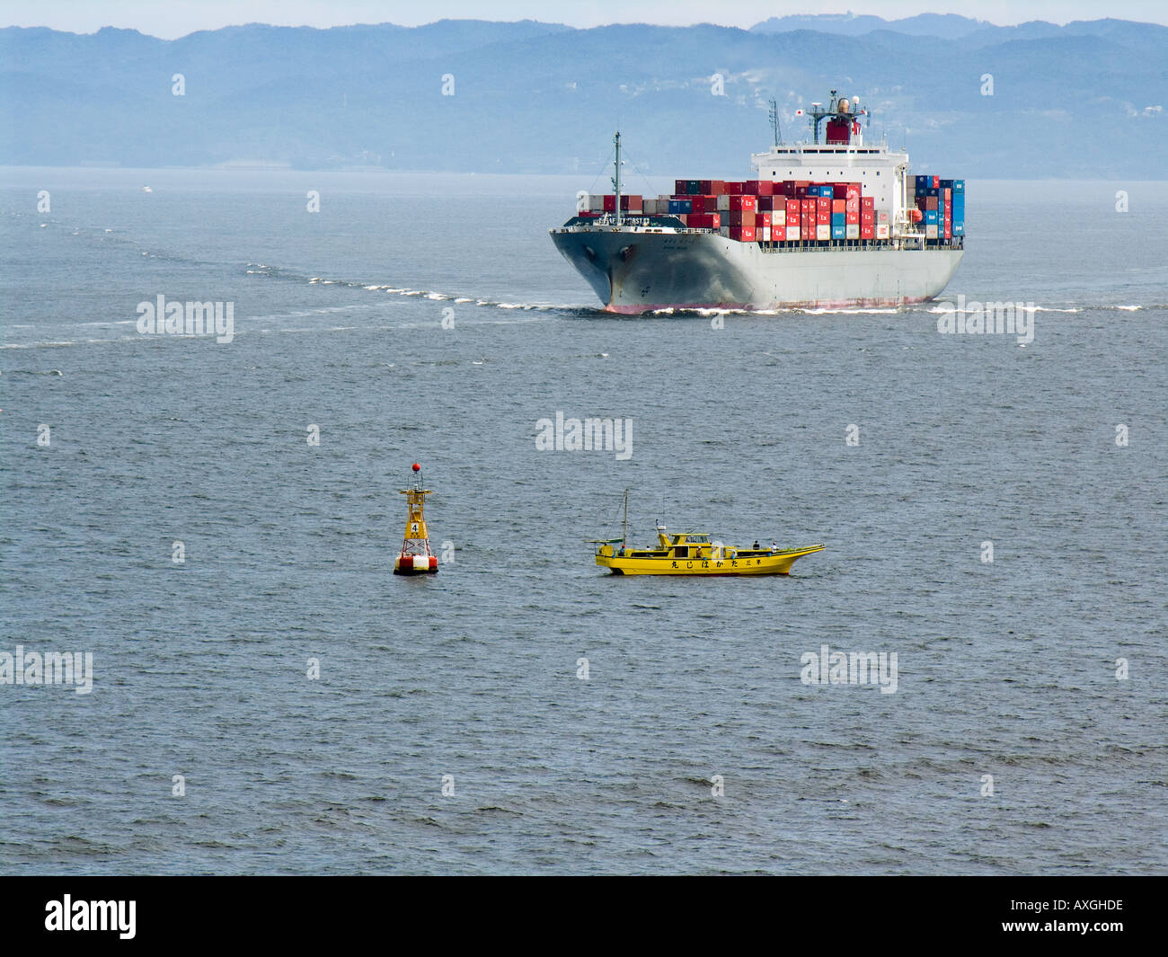 Small fishing boat by buoy approached by ladge container vessel Stock ...