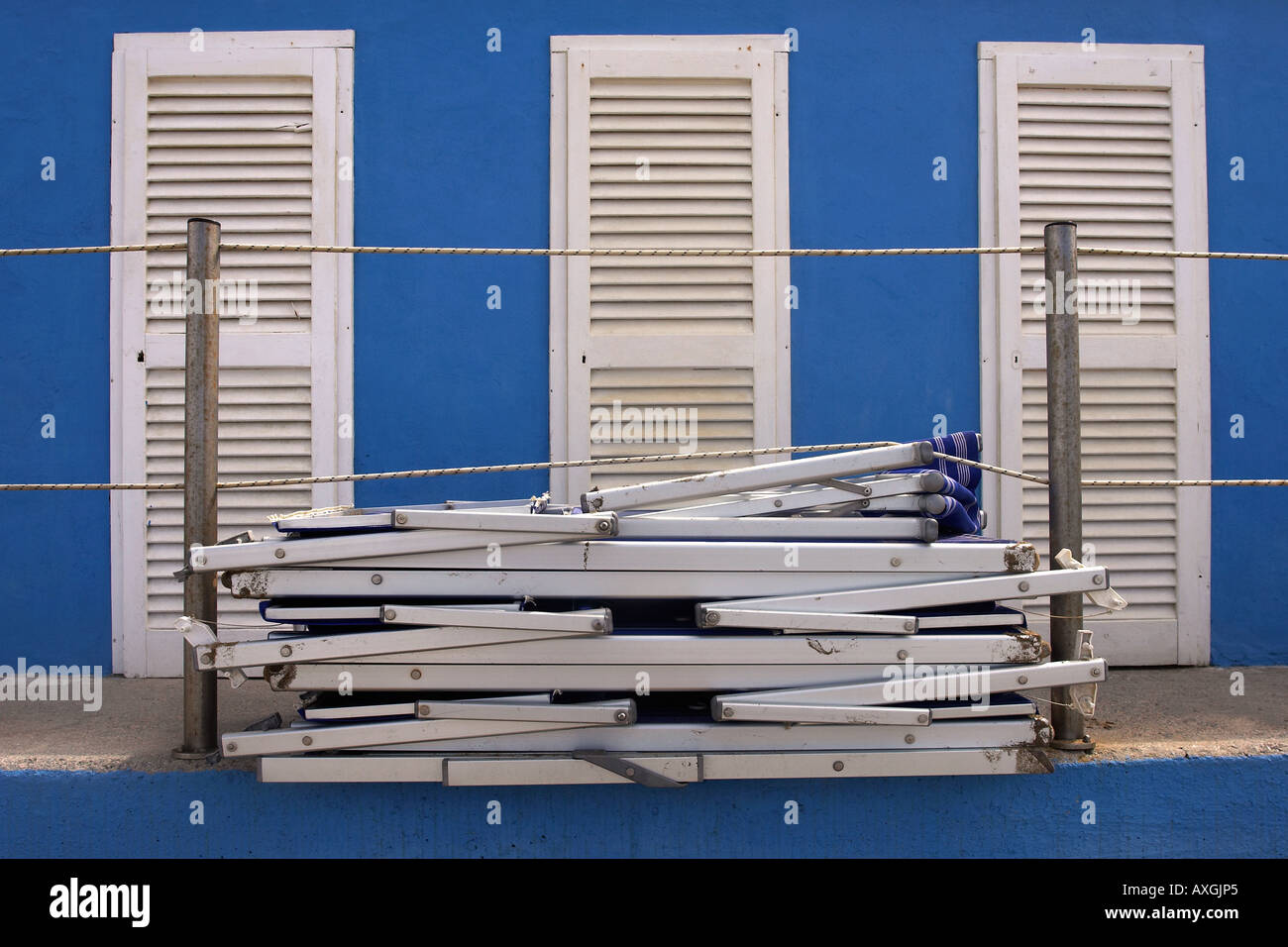 Beach hut changing rooms and folded deck chairs Stock Photo - Alamy