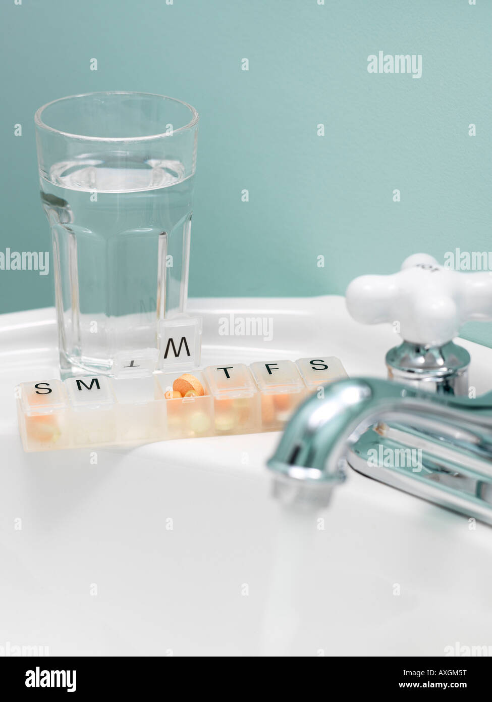 Pills and Glass of Water on Edge of Sink Stock Photo - Alamy