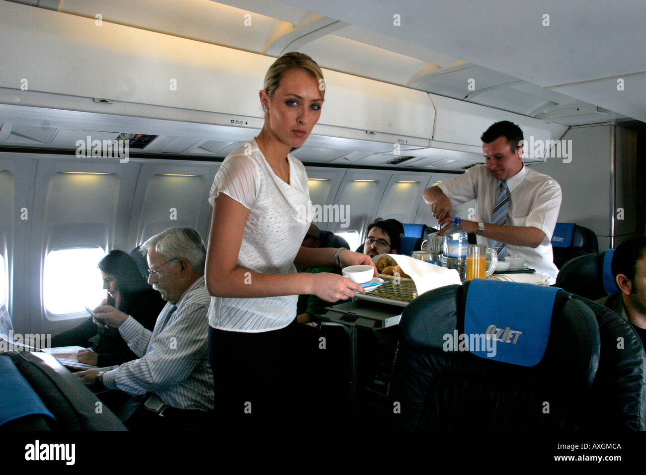 Flight attendants serve refreshments in a business class cabin Stock ...