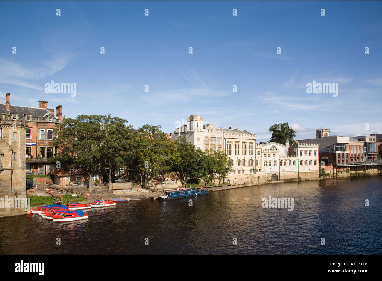 View waterfront city buildings and moored boats along River Ouse. York ...