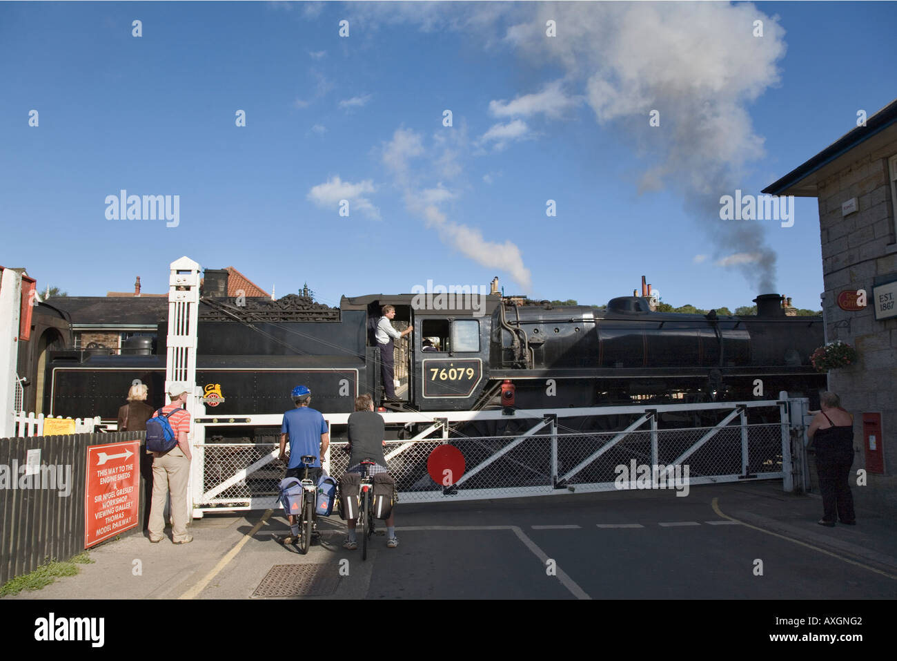 Steam train pulling out of station on level crossing on North Yorkshire ...