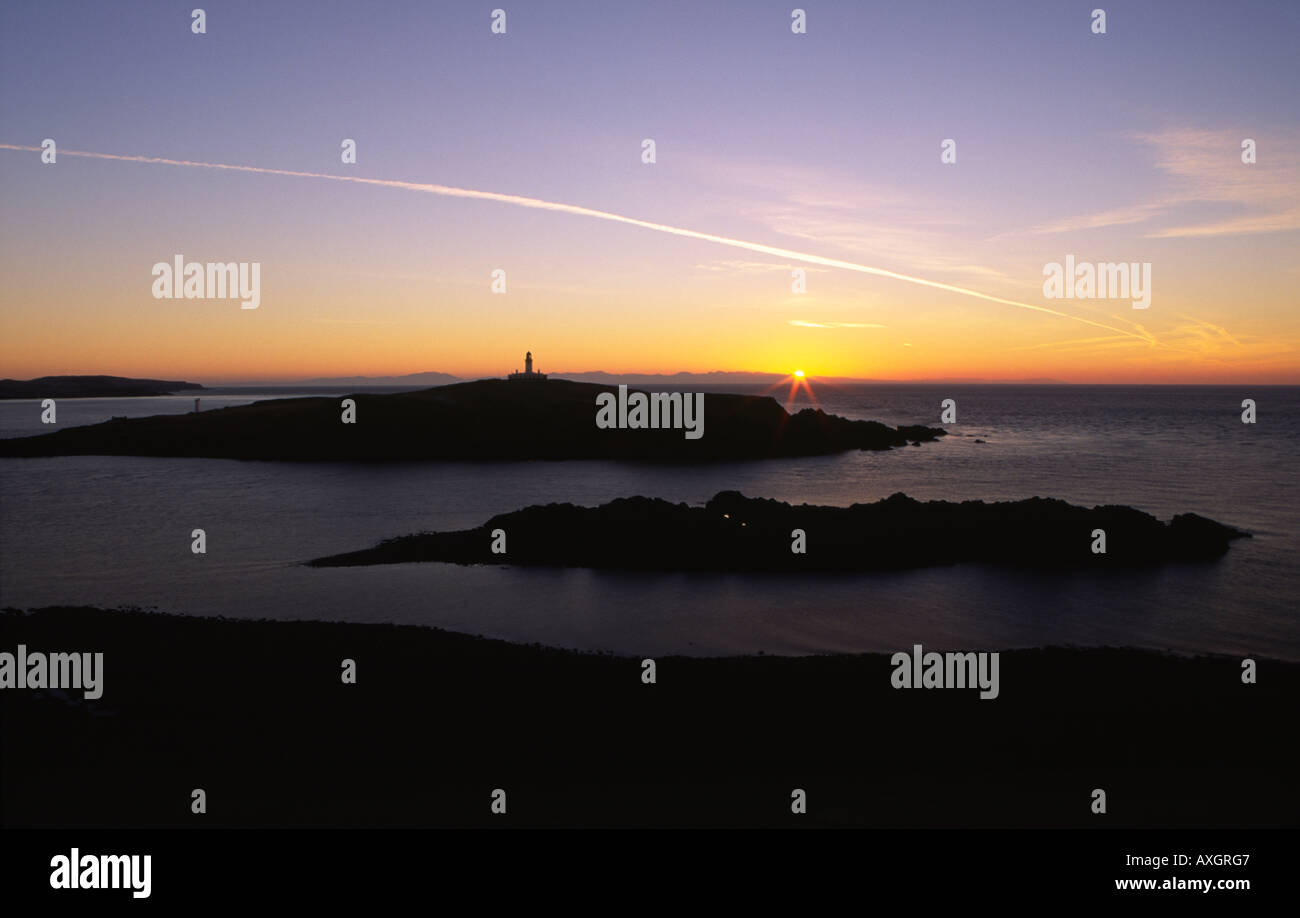 Lighthouse silhouetted against Solway Firth sunrise Stock Photo - Alamy