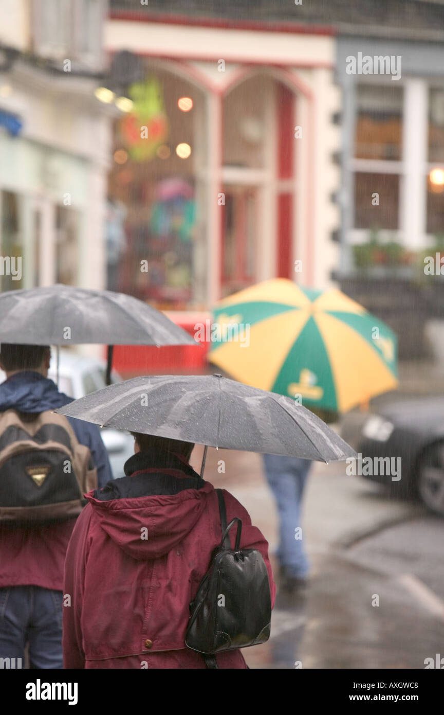 people sheltering under an umbrella in the rain Stock Photo - Alamy